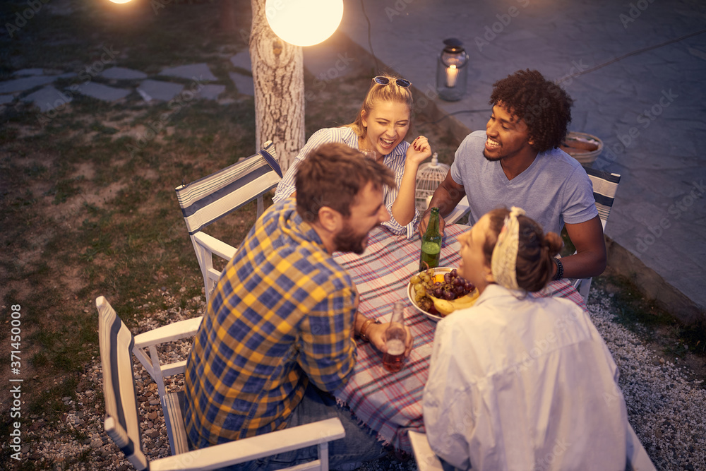 Summer evening in the garden, a group of friends have a good time ...