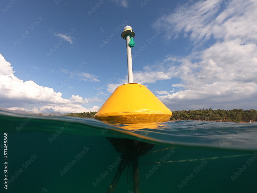 Underwater split photo of yellow ship navigation floating sea buoy ...