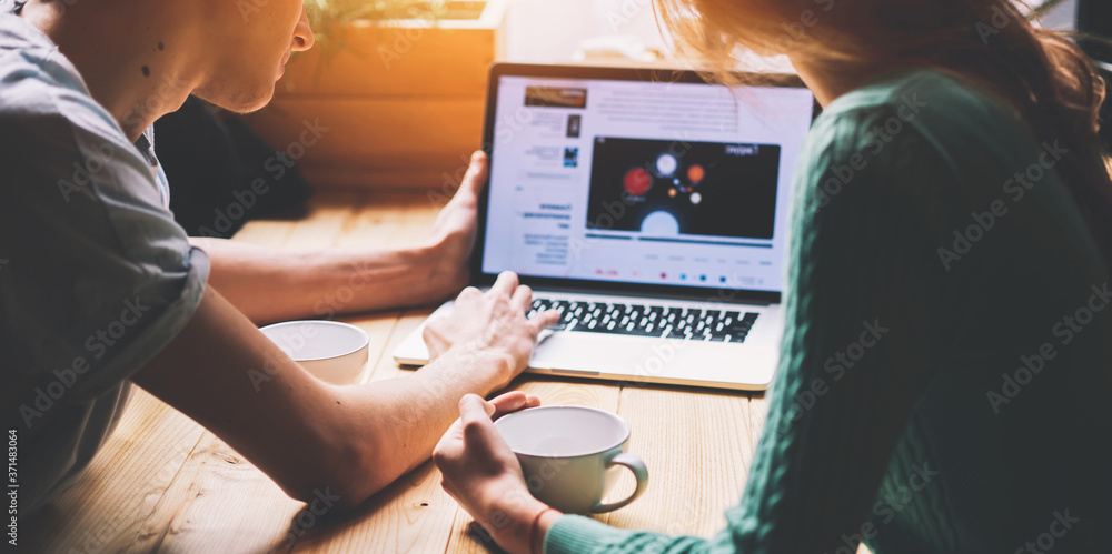 Cropped image of group of young students are watching movie on laptop ...