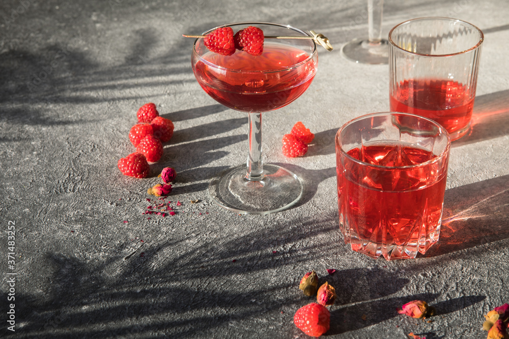 Smash gin alcoholic cocktail. Long raspberry drink on gray stone ...