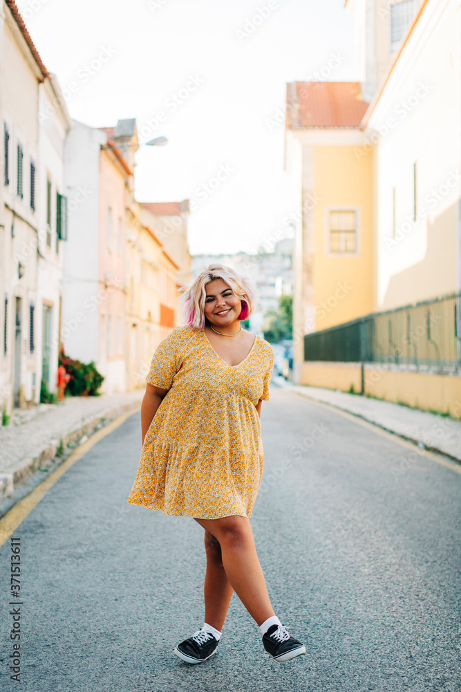 Smiling plus size woman standing with crossed leg on road Stock Photo ...