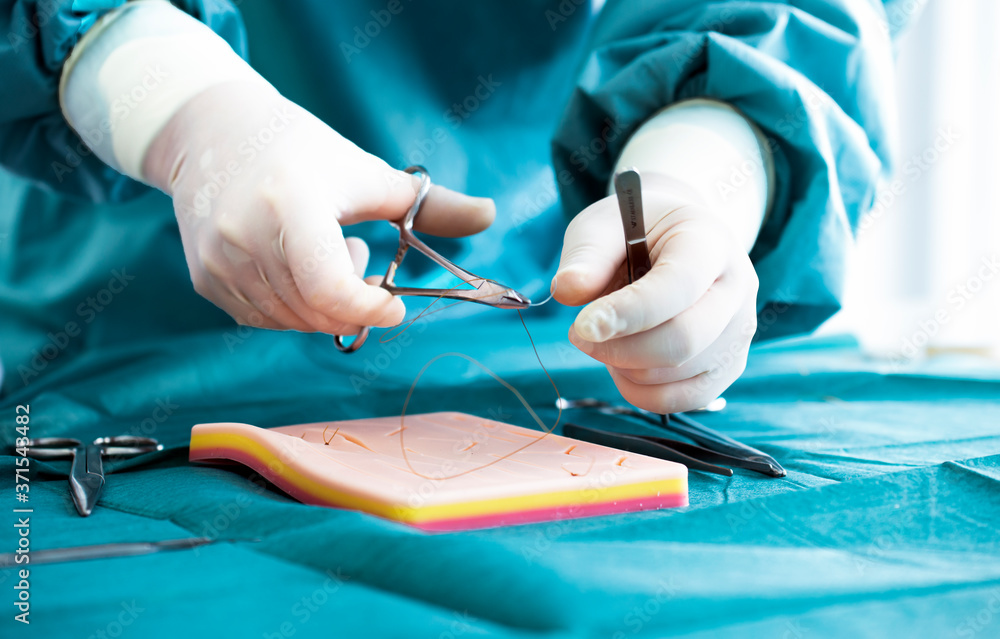 Doctor teaches the technique of suturing and closure on silicone pad ...