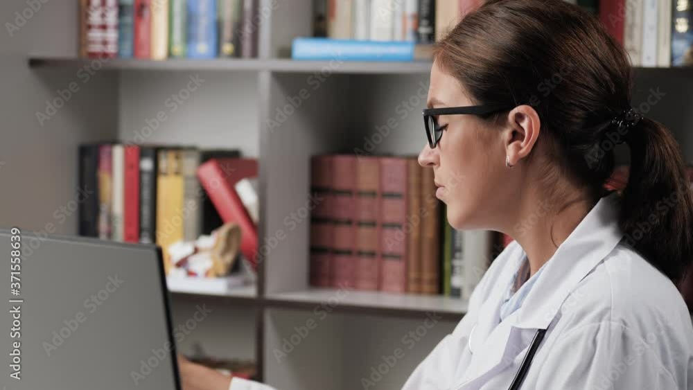 Vídeo do Stock: Doctor reads x-ray or MRI scan. Concentrated woman ...