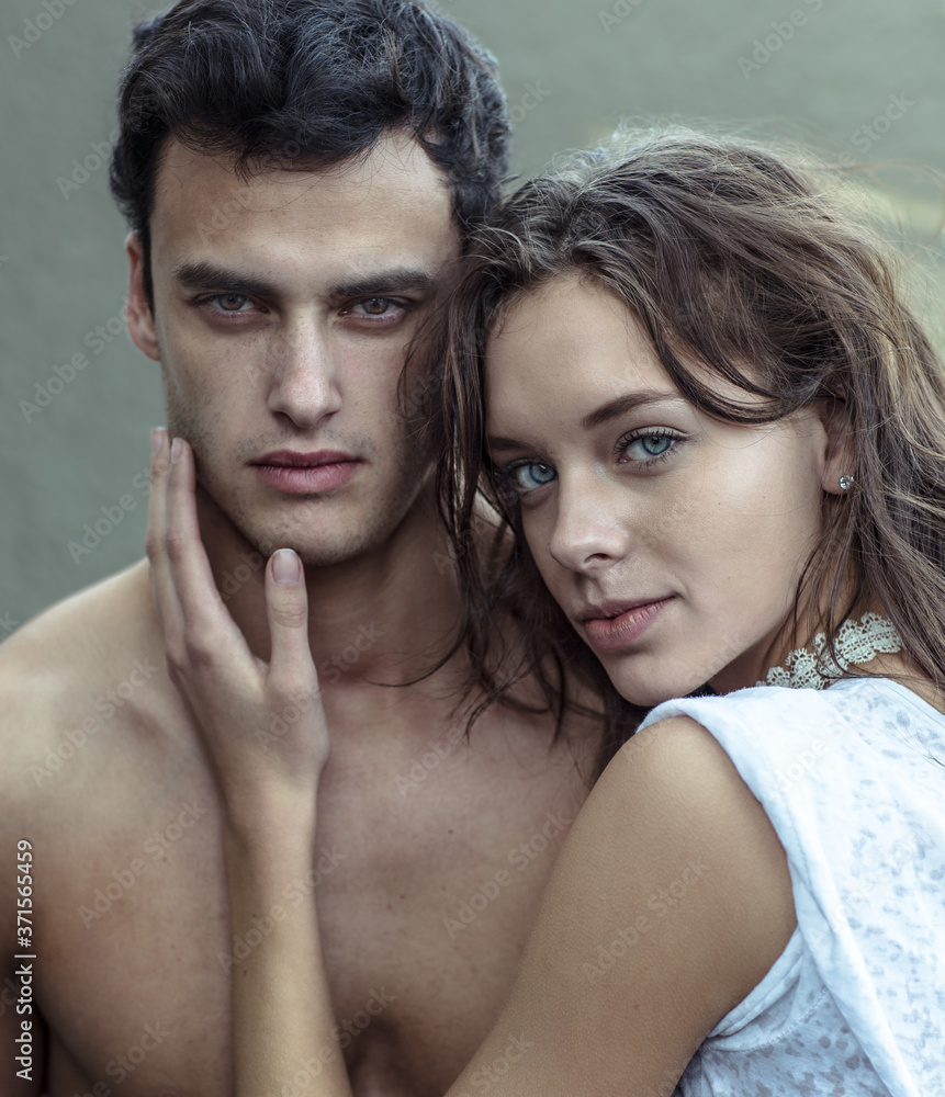 Intimate male and female fashion model couple staring at the camera and ...