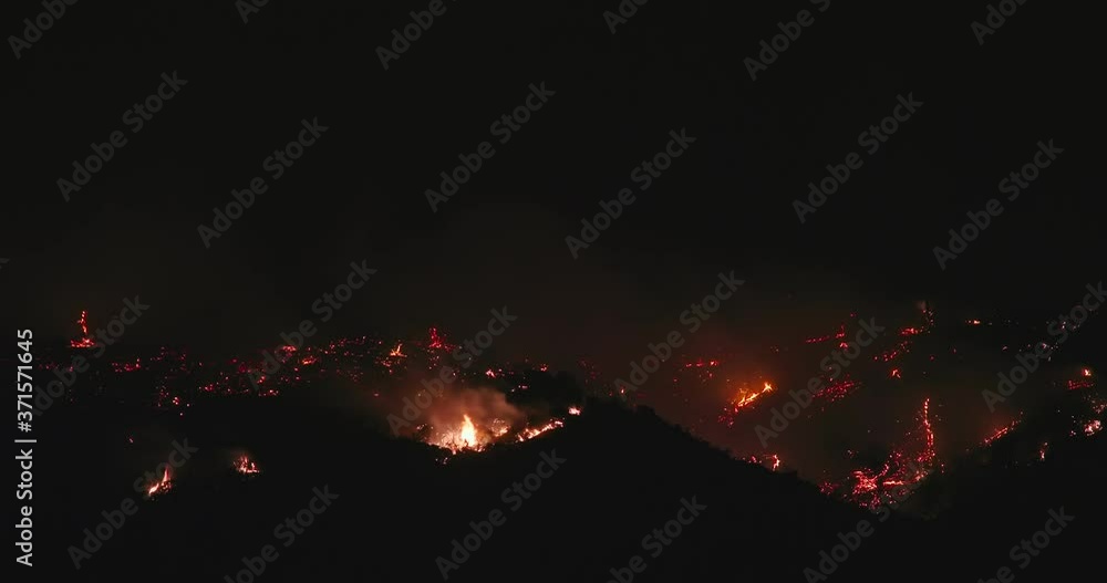 Wild fire on late night in the dark. Nature is on fire, red flames are ...