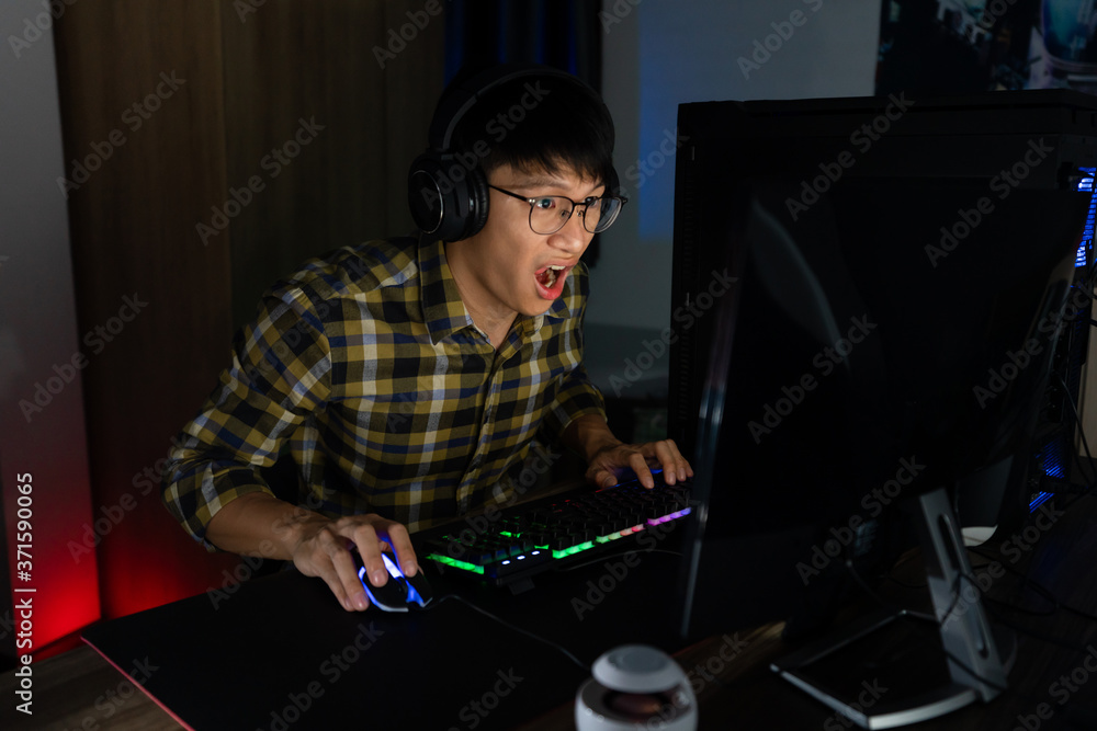 Involved asian man cyber sport gamer concentrated playing video games ...