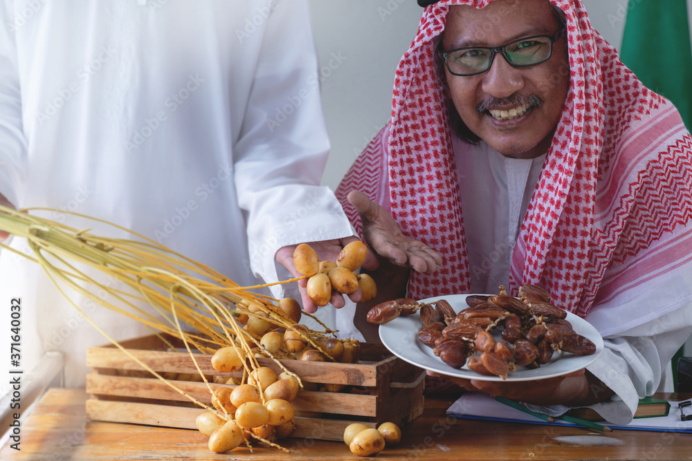 Arab senior man showing agricultural products from his farm, Date palms ...