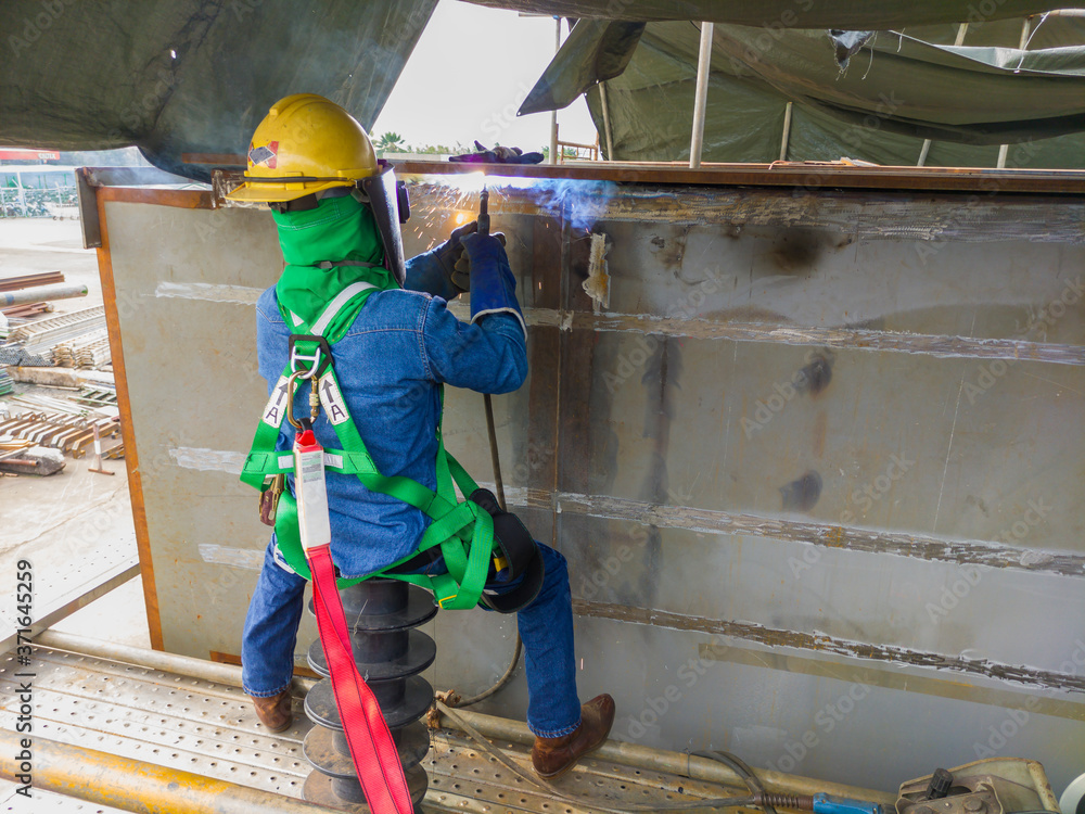 The welder is welding a steel structure work with process Flux Cored ...