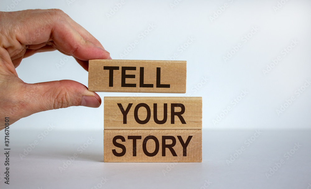 Male hand placing a block with word 'tell' on top of a blocks tower ...