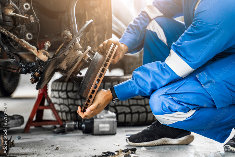 Mechanic Asian man close up fixing repairing car rotor spindle hub ...