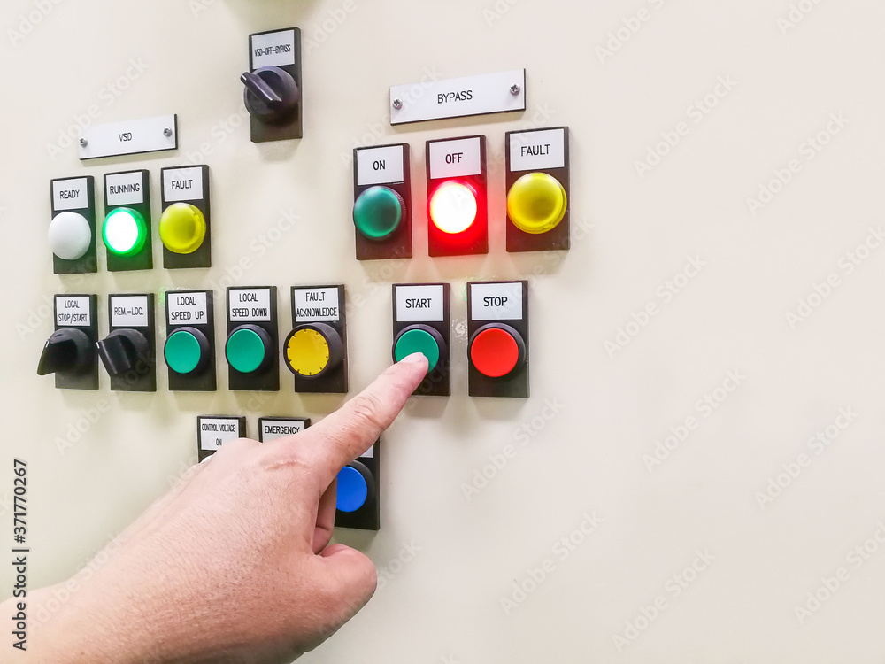 Hand holding the control panel of the industrial plant and pushing or ...