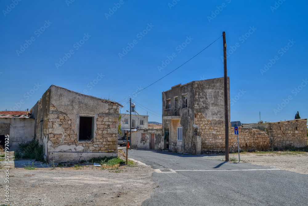 Street of the town of Kouklia, Cyprus. Asphalt road surrounded by old ...
