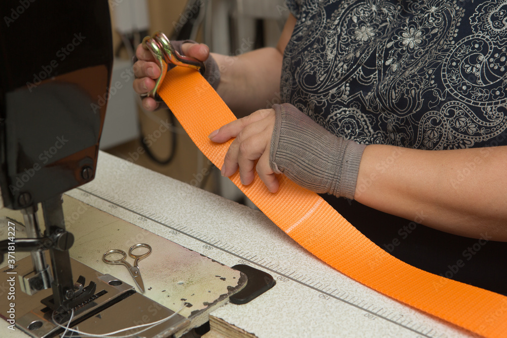 Industrial sewing machine sews a webbing sling. Manufacture of textile ...
