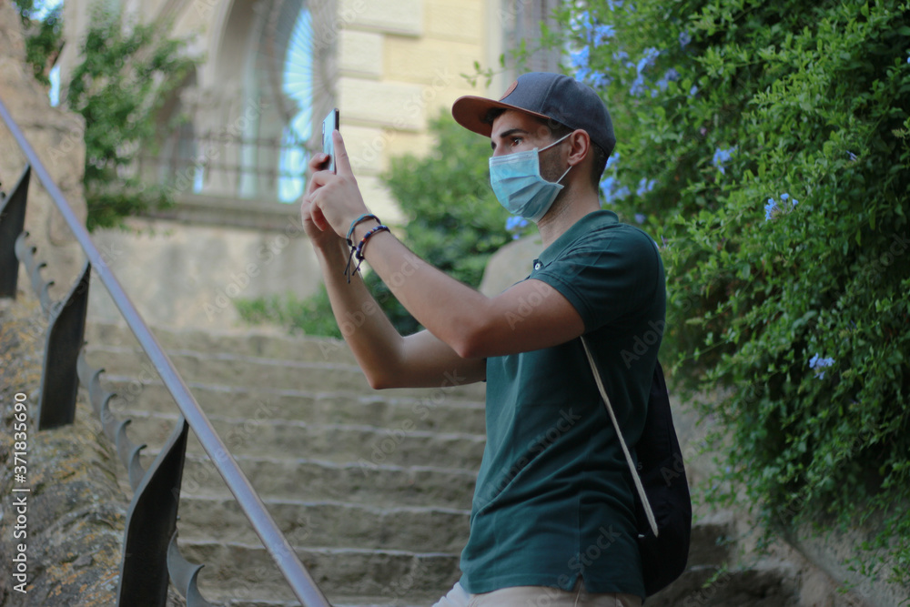 Young Boy taking a photo with his smarthphone, while is wearing a hat ...