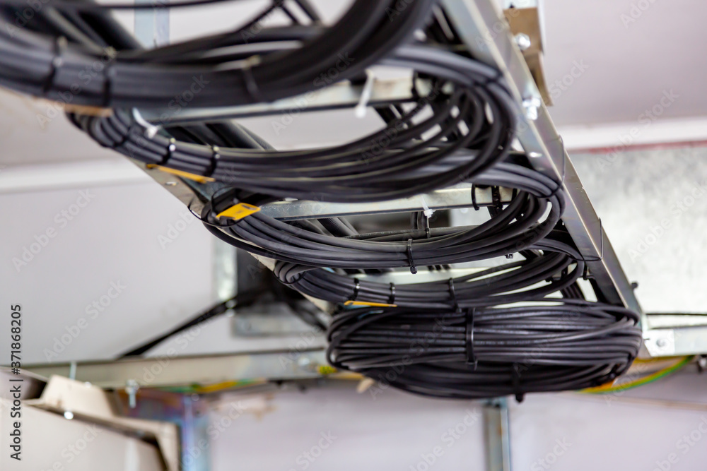 Cable management. Working wires, black cables wound into a coil, a ...