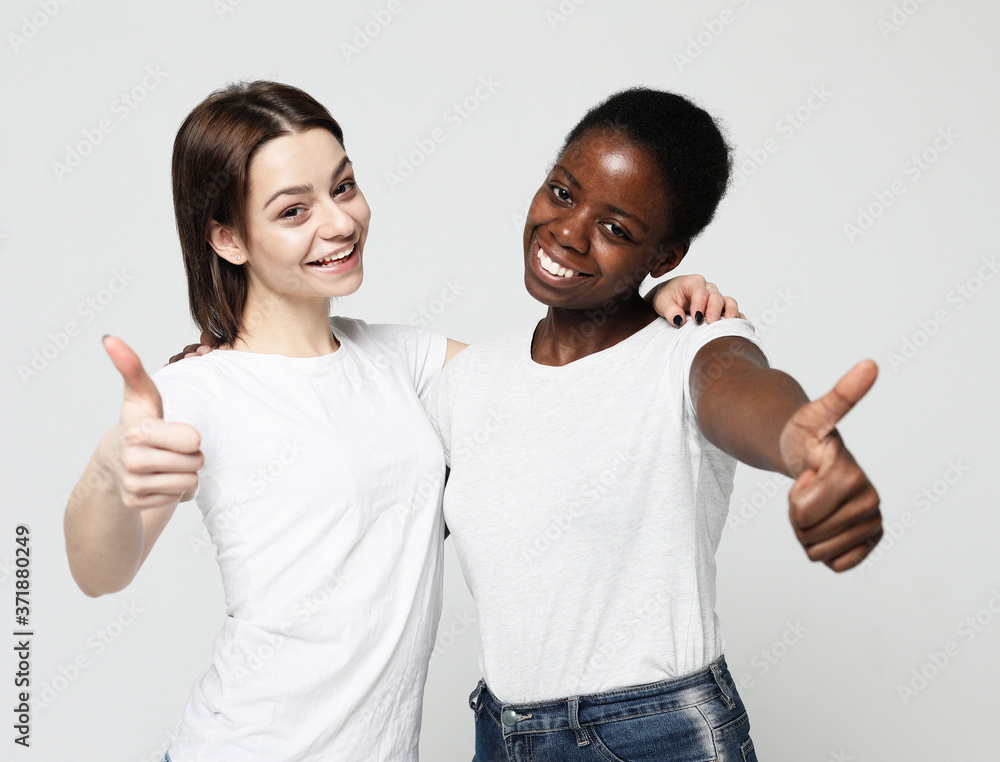 young multiracial women standing together and smiling at camera ...