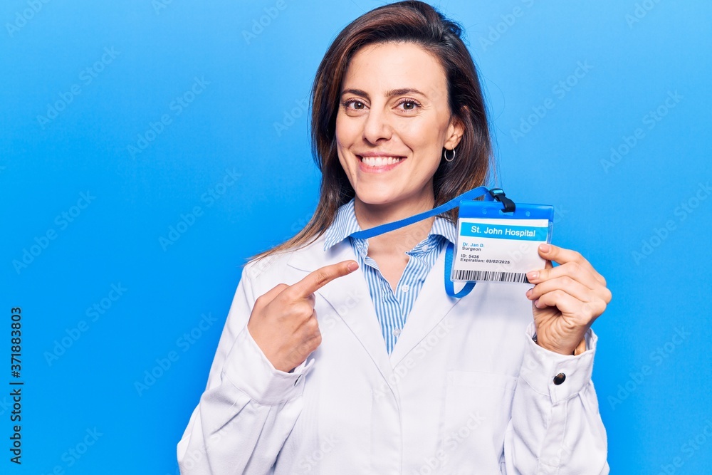 Young beautiful woman wearing doctor stethoscope holding id card ...