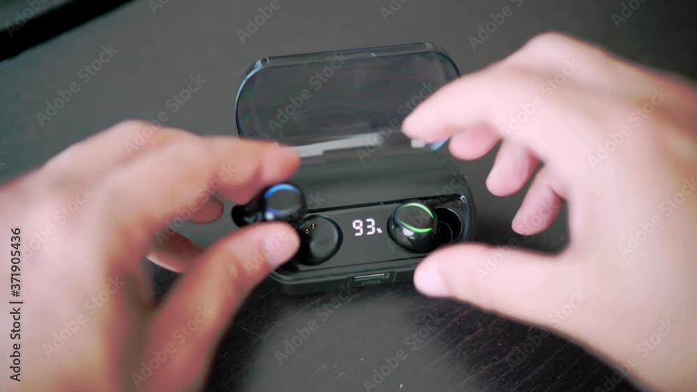 Putting in wireless bluetooth earbuds to it's charging case and it ...