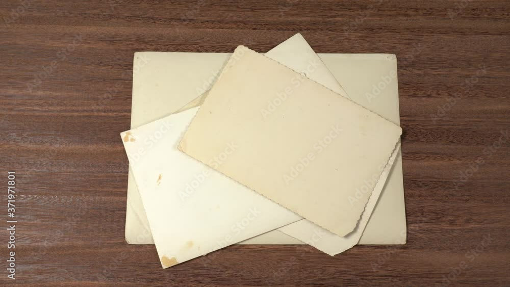 Stack of old vintage paper photos stacked together on brown wooden ...