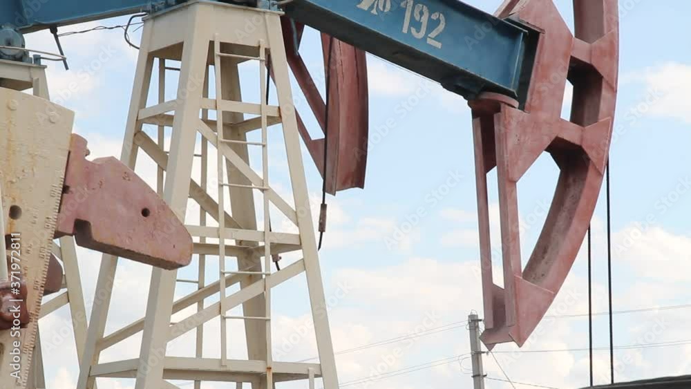 Vidéo Stock Oil pump close up on a background of blue sky with clouds ...