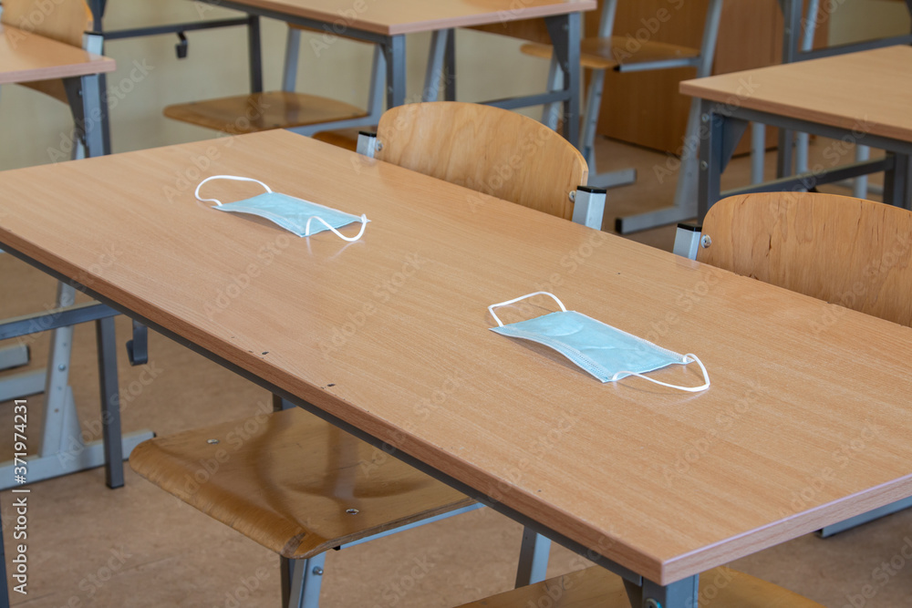 School desk in a school classroom with a face mask. School safety ...