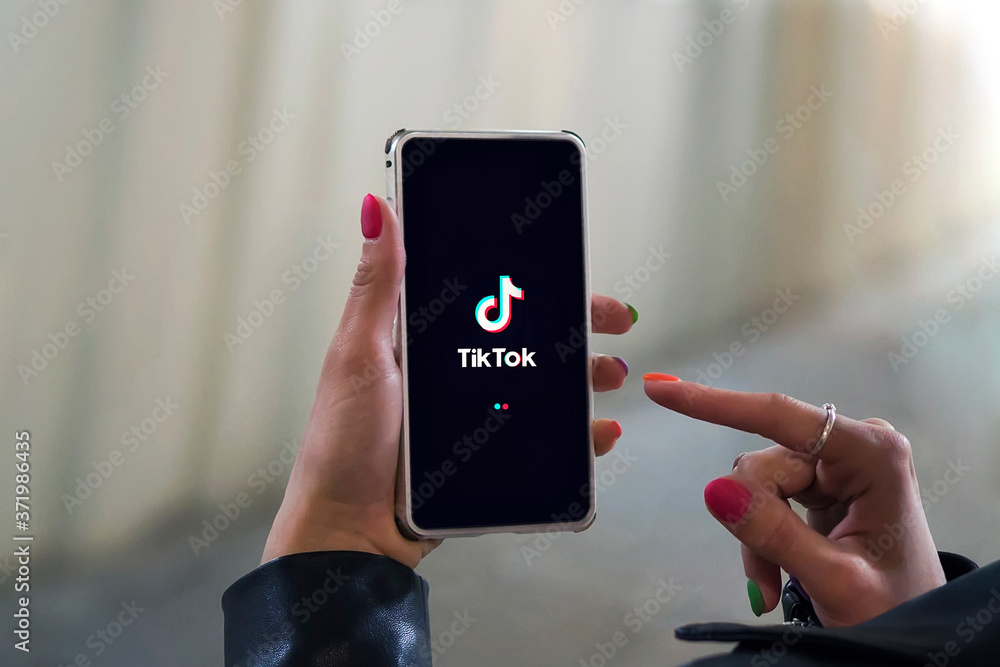 Women holding Phone with TikTok logo on the screen. Tik Tok is app to ...