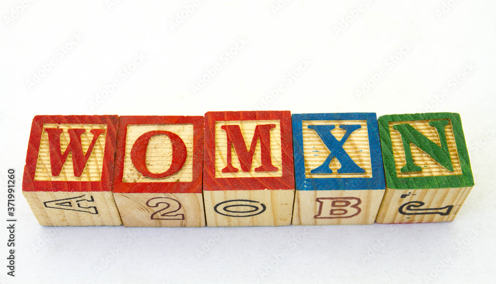 The term womxn visually displayed on a clear background using colored wooden blocks image with ...