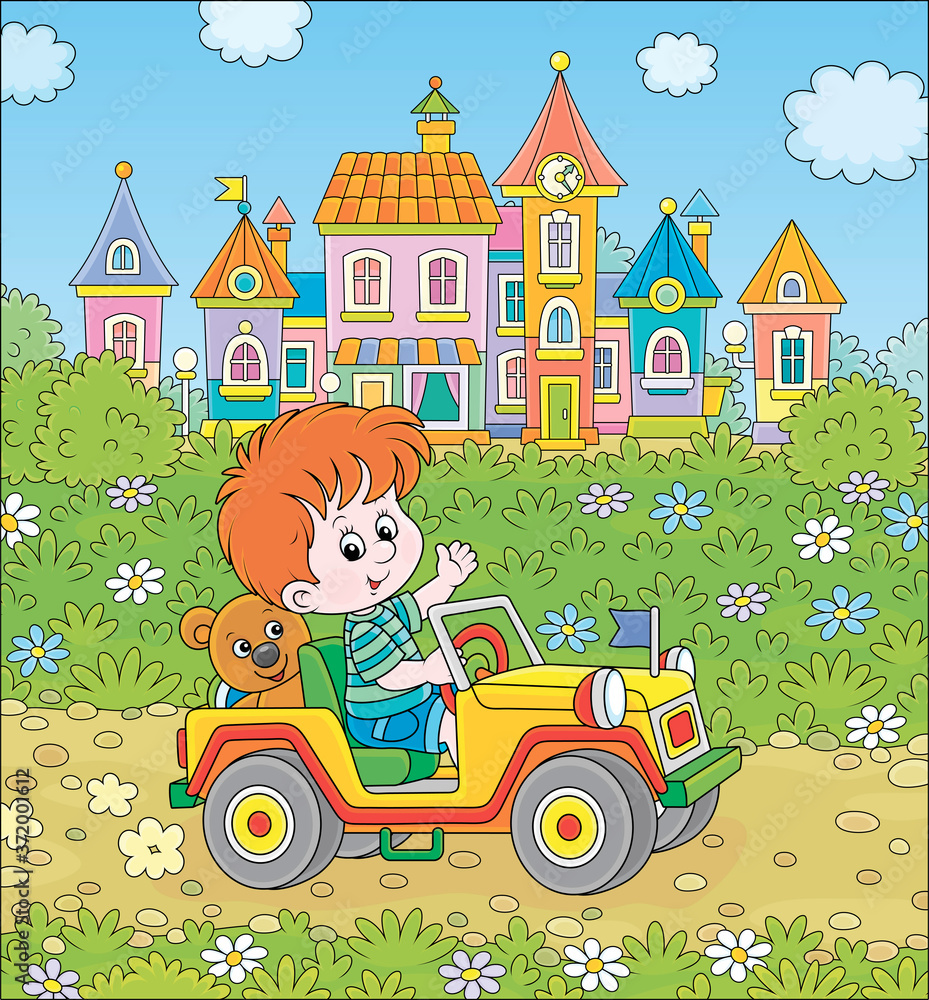 Little boy driving a toy off road car on a road out of town on a summer ...