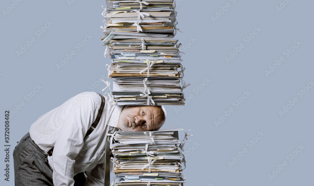 Stressed businessman under a pile of paperwork Stock Photo | Adobe Stock