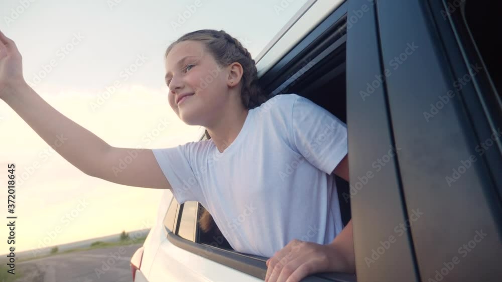 happy girl kid child leaned out of a car window waving hand. happy ...