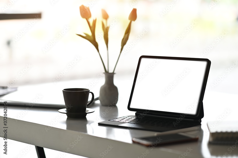 Computer tablet with a white blank screen is putting on a table ...