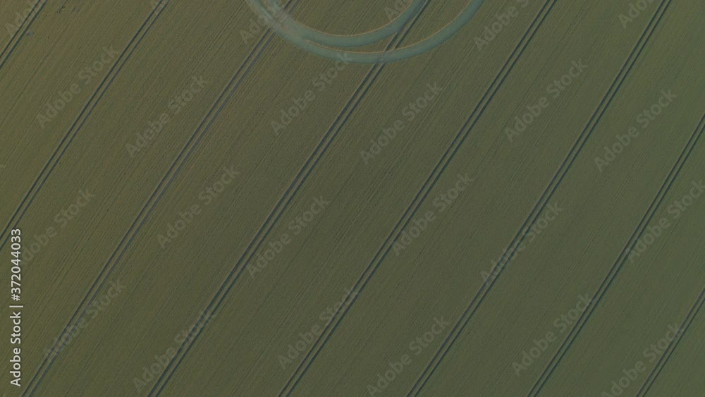 Top down aerial slow drone drifting shot of a field, farm cropland with ...