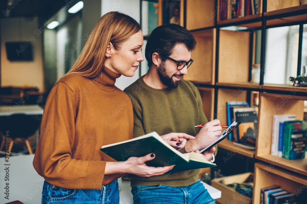 Positive man and woman preparing for exam spending time at university ...