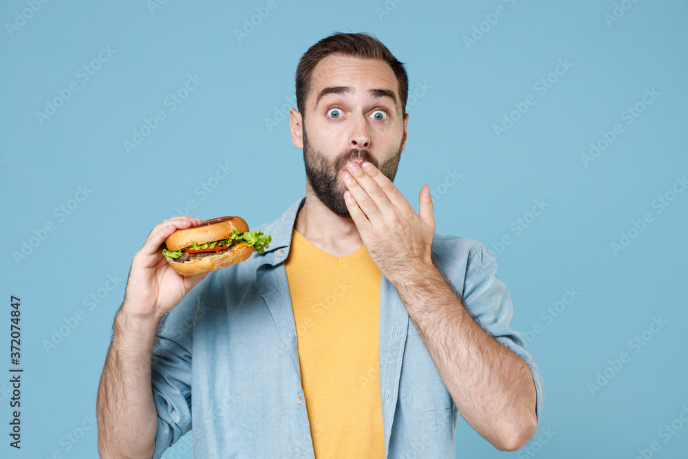 Shocked young bearded man guy 20s in casual clothes posing hold ...
