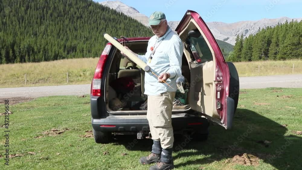 Hopeful, solitary Fly fisherman assembles a split cane fly rod prior to ...