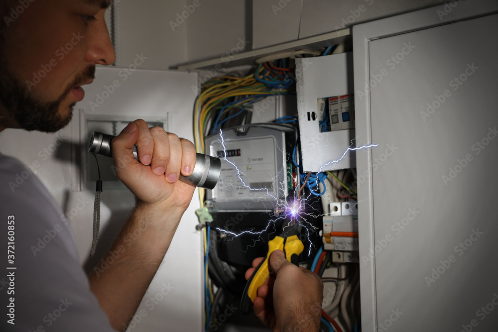 Electrician receiving electric shock while working, closeup Stock Photo ...