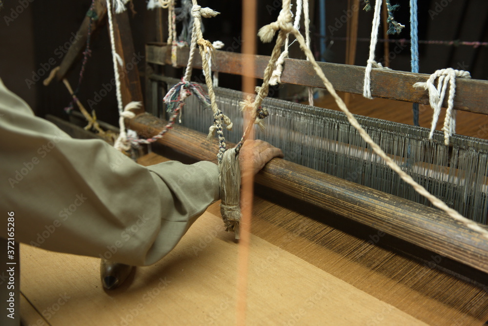 old weaving method, a man is making hand made cloth khadar on khadi ...