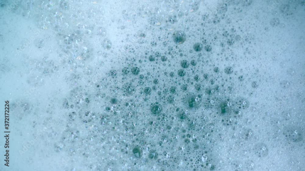 Top view of foamy soapy water texture. White suds and clean water ...