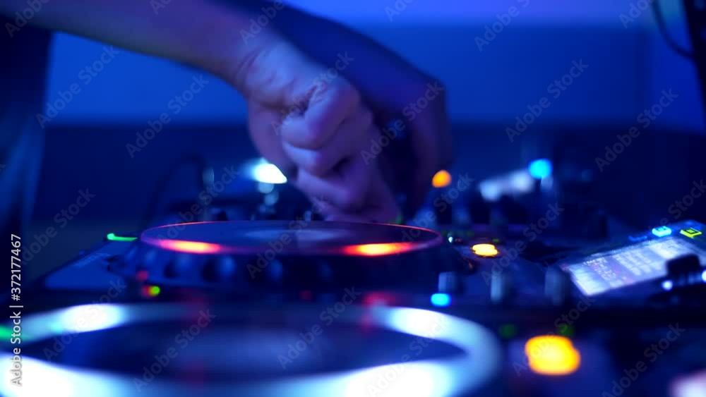 DJ hands on CDJ in nightclub turning and pushing buttons, and ...