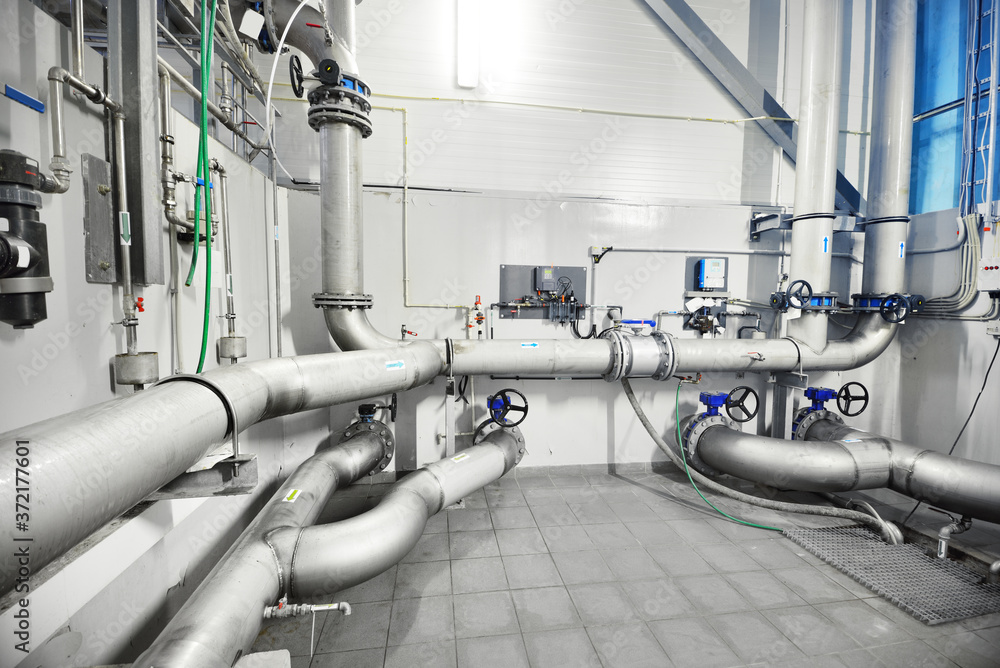 Large blue tanks in a industrial city water treatment boiler room. Wide ...