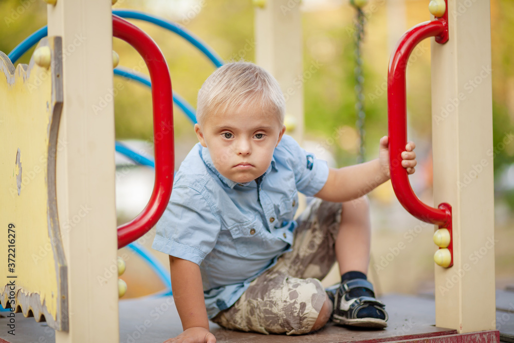 The daily life of a child with disabilities. A boy with Down syndrome ...