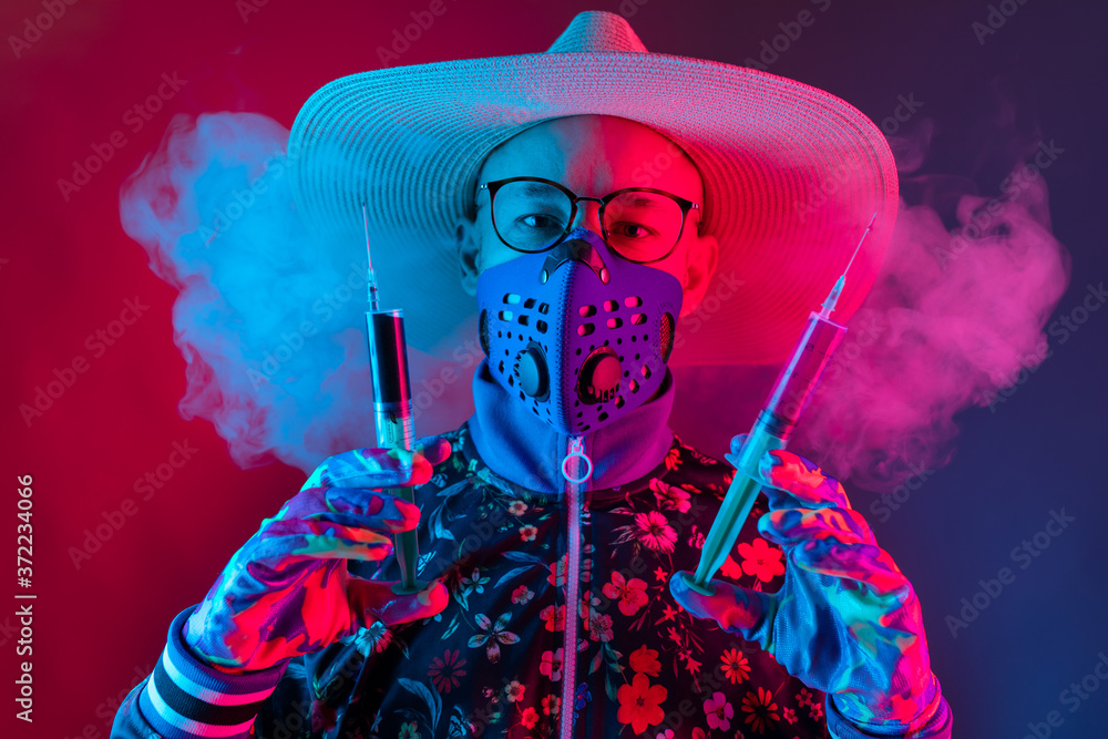 Strange man in medical respirator mask, glasses and hat holding two ...
