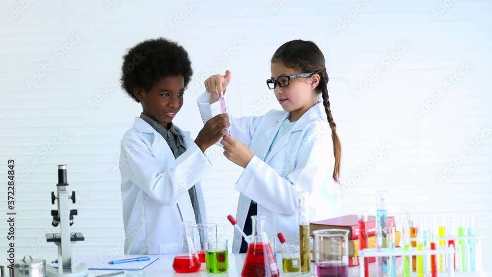 Kid in lab coat learning chemistry in school laboratory, Kid scientist ...