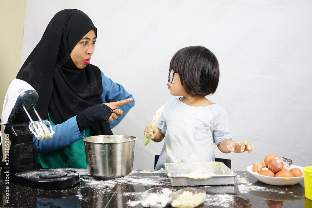 Asian muslim mother with hijab and cute daughter preparing the dough to ...