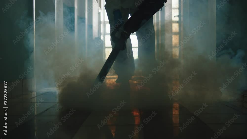 This video shows a man in protective overalls sanitizing a school ...