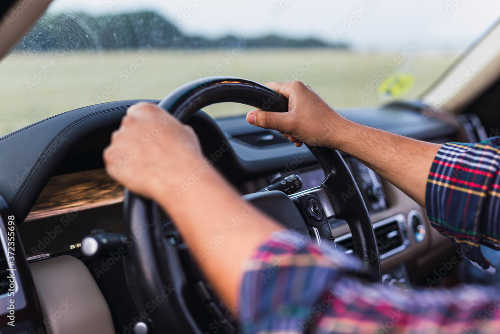 Manos agarrando un volante de un coche Stock Photo | Adobe Stock