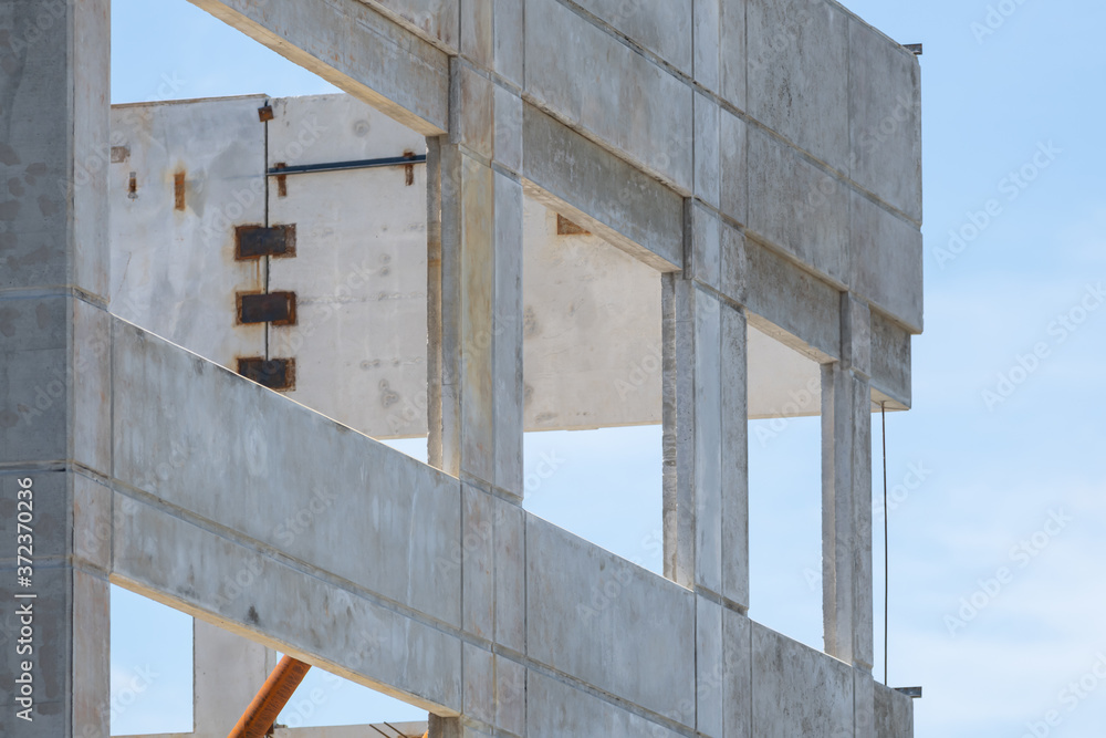 Multiple story precast grey concrete building with steel beams. The ...