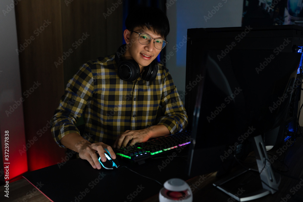 Handsome excited asian gamer guy in headphones enjoy and rejoicing ...