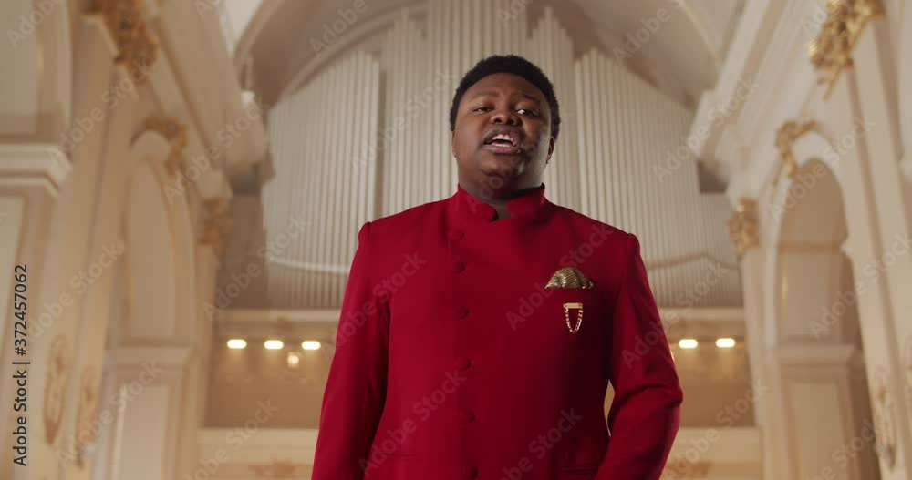 Afro american man singing gospel music. Young male singer in red suit ...