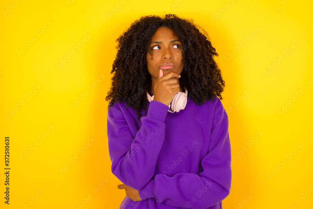 Shot of contemplative thoughtful Young woman keeps hand under chin ...